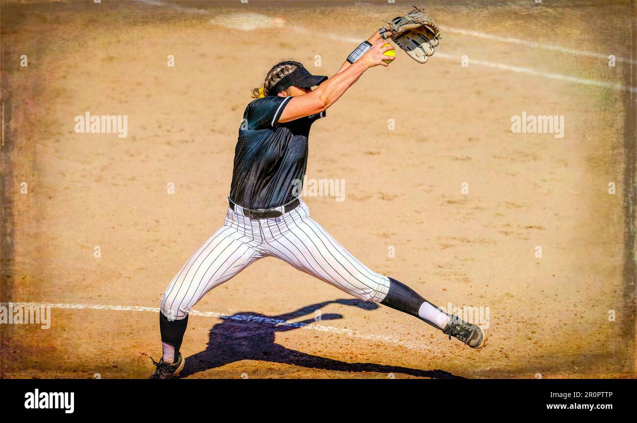 A Female Softball Player Is Pitching The Baseball In Full Windup Stock ...