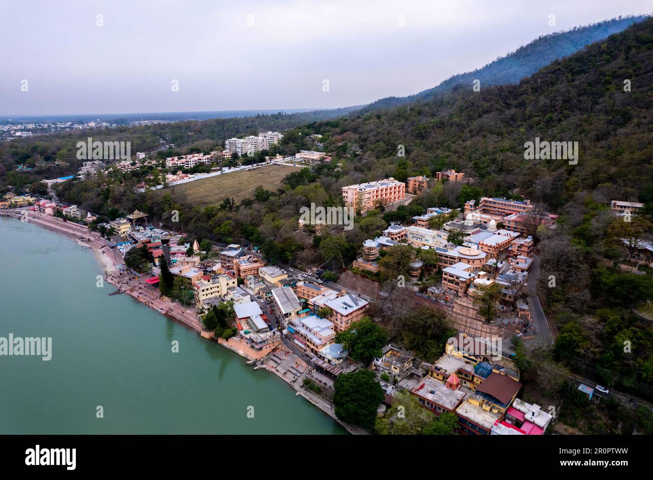 aerial drone shot of buildings apartments and temples on bank of ganga ...