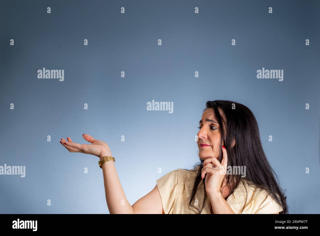 A young Caucasian woman with a thoughtful expression on her face ...