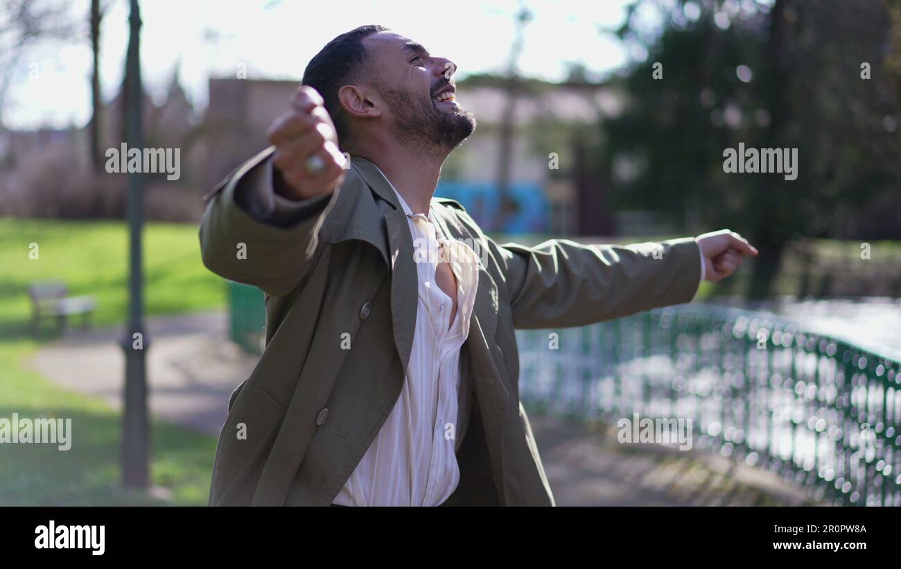 One Elated young man celebrates life feeling joy and happiness dancing ...