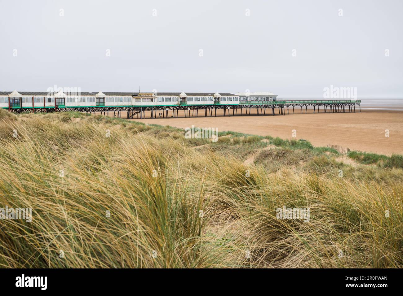 St Anne's Pier painted in green and white seen behind sand dunes on the ...
