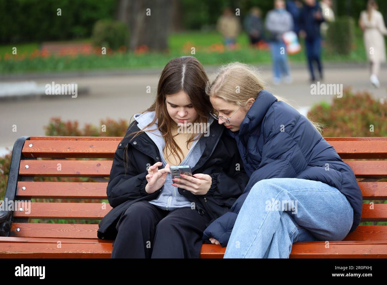 Two girls talking on bench hi-res stock photography and images - Alamy