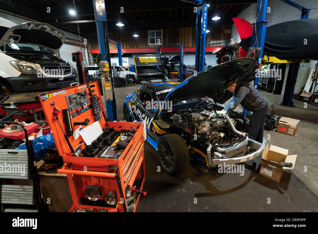 Mechanic David Stoliaruk works the internal combustion engine of a car ...