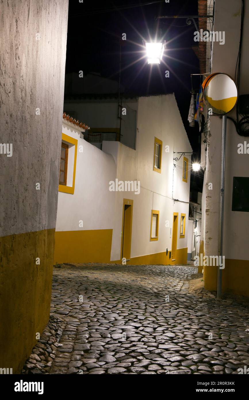 Typical Portuguese facades and cobblestone streets at night in Evora ...