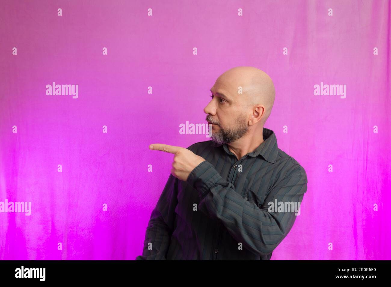 Portrait of serious man, 50 years old, with beard and bald head making ...