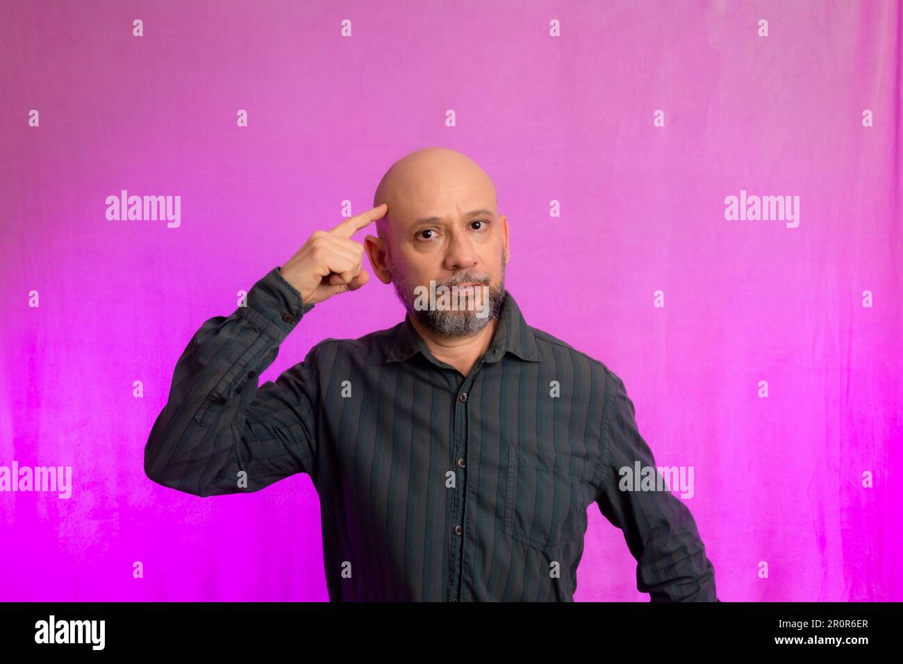 Portrait of serious man, 50 years old, with beard and bald head making ...