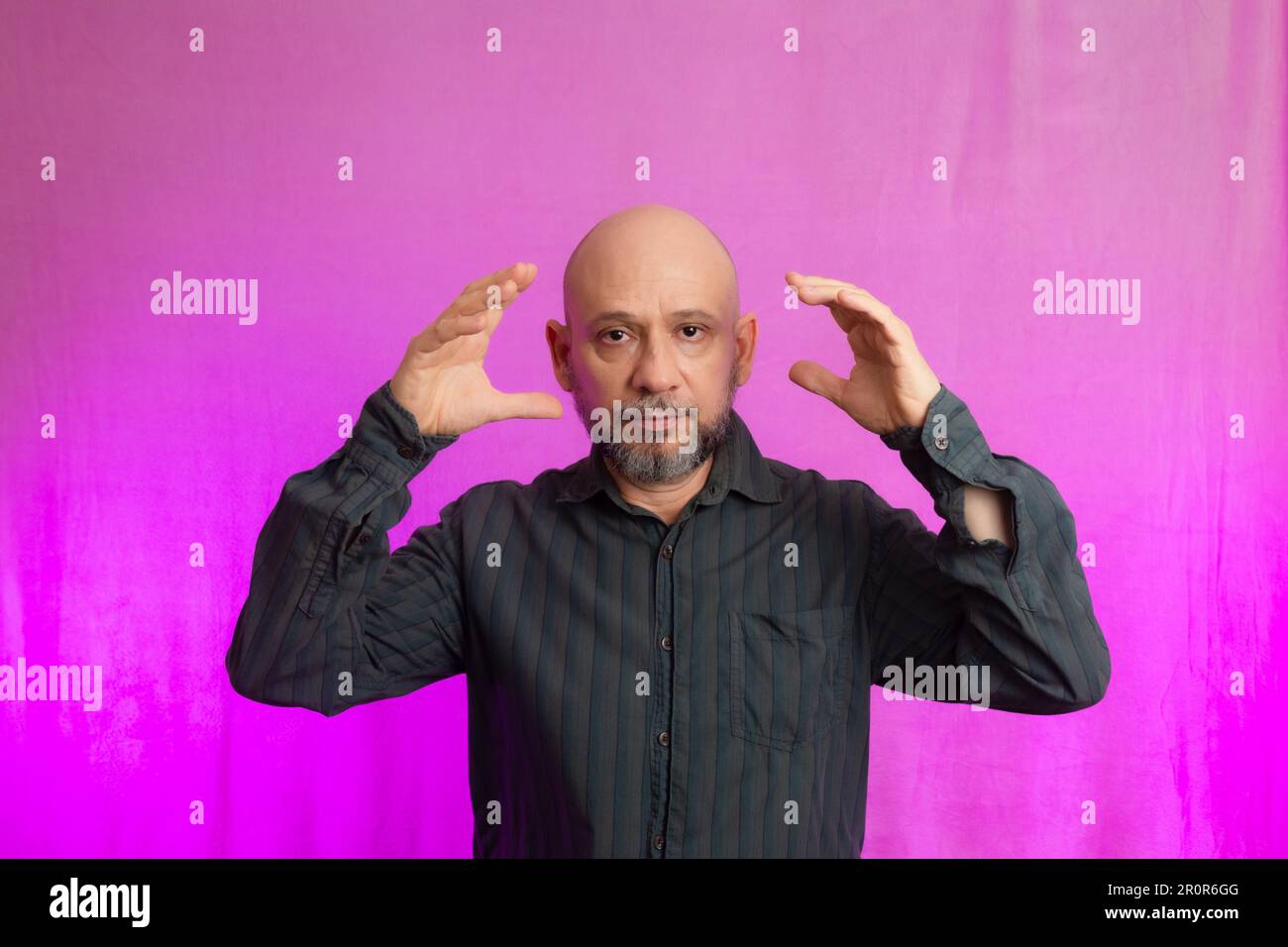 Portrait of serious man, 50 years old, with beard and bald head making ...