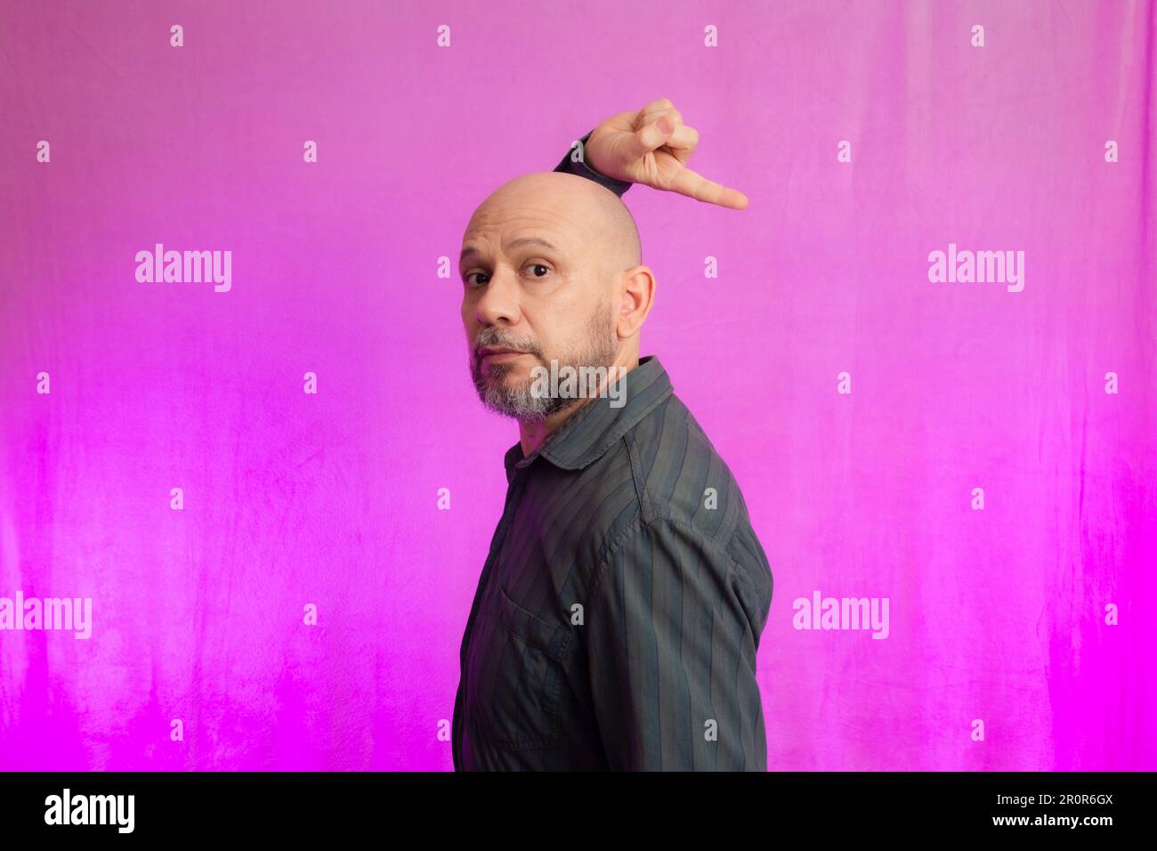 Portrait of serious man, 50 years old, with beard and bald head making ...