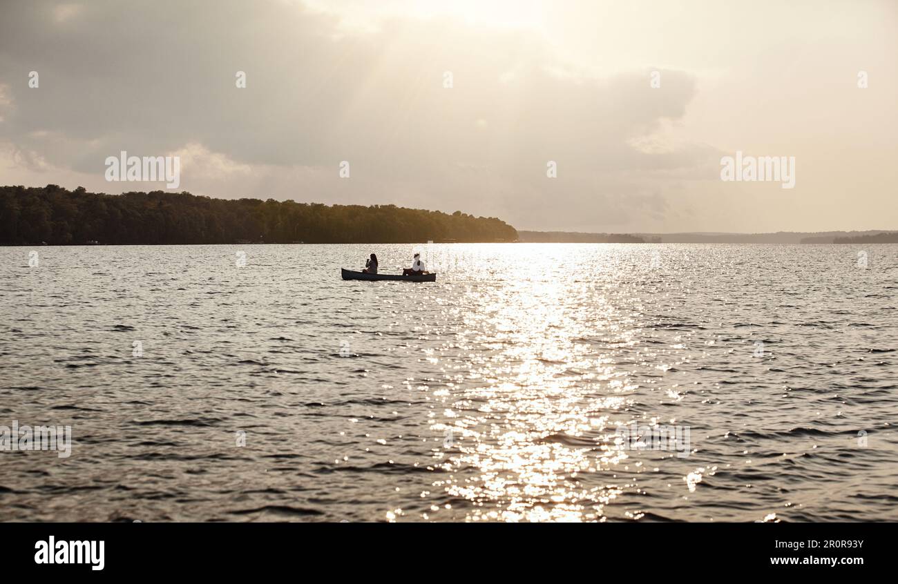 Mesmerised by the view. an unrecognizable couple rowing a boat out on ...
