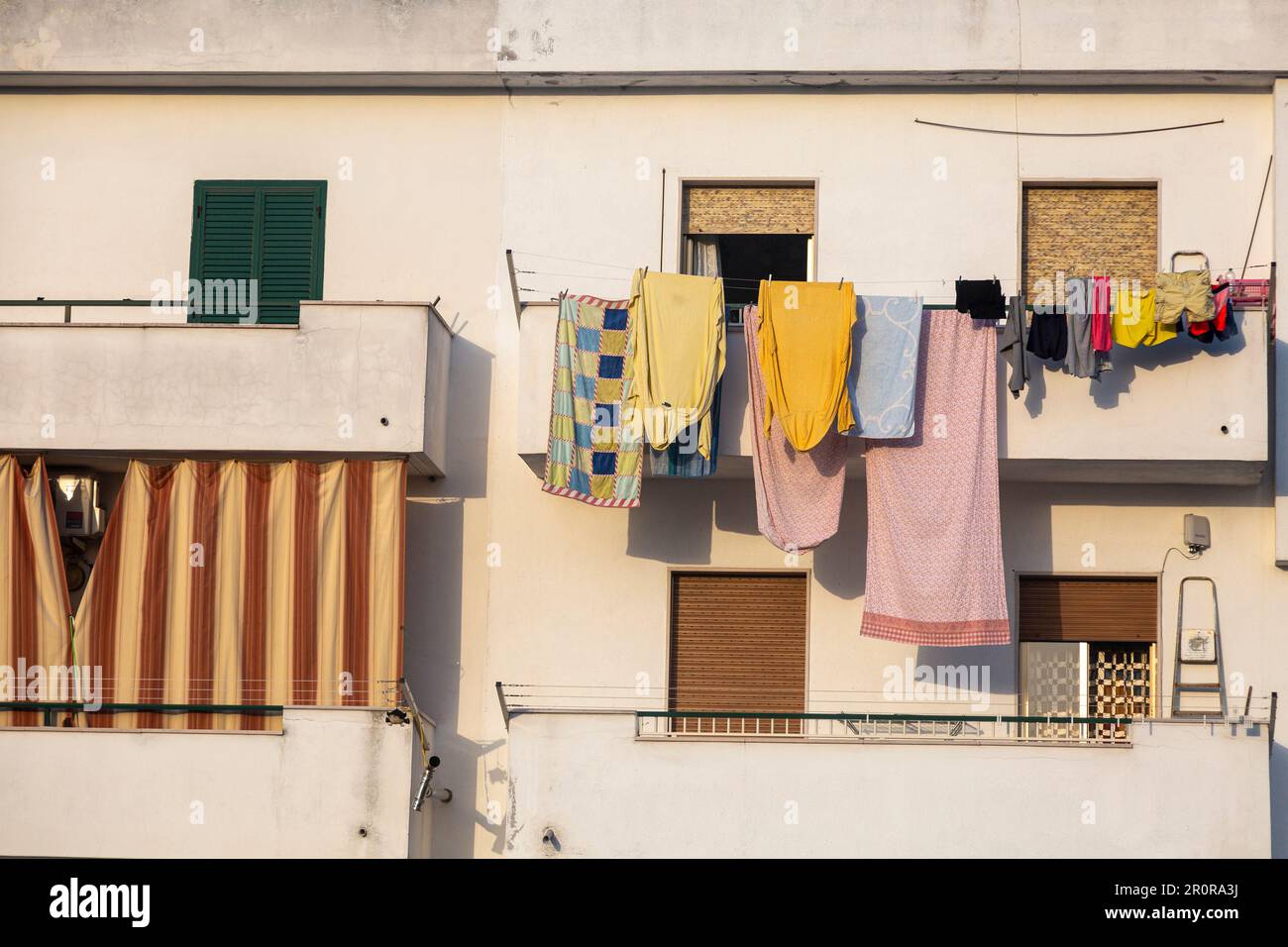 A balcony with a striped awning. Clothes drying on a line Stock Photo ...