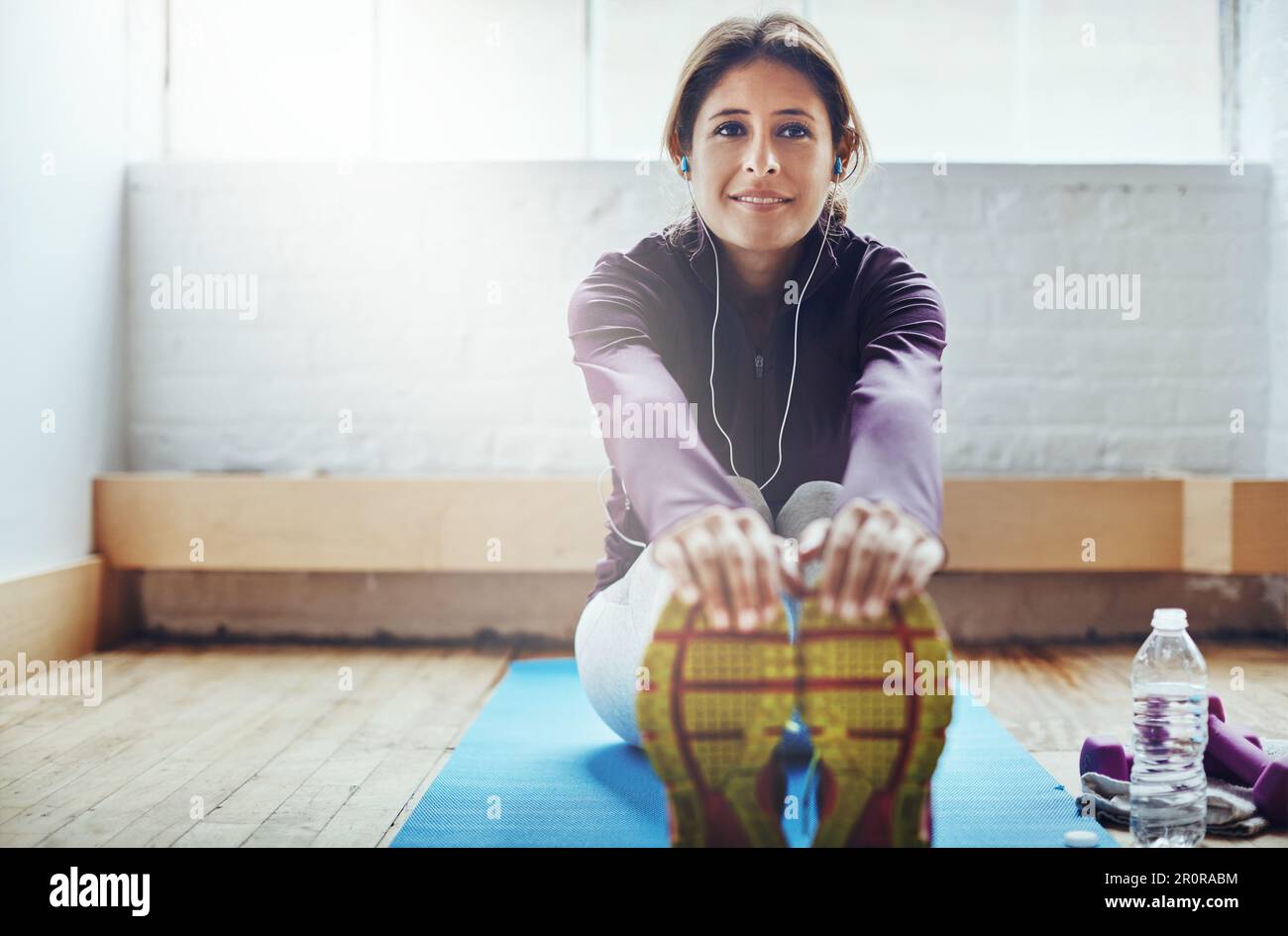 Getting in a few good stretches. an attractive young woman listening to ...