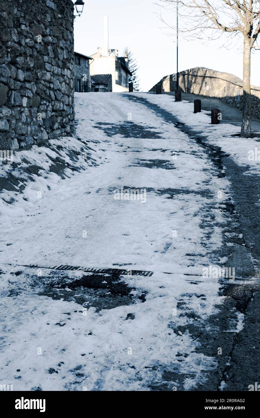 Snowy cobble stone paved road covered with ice and snow in a townscape ...