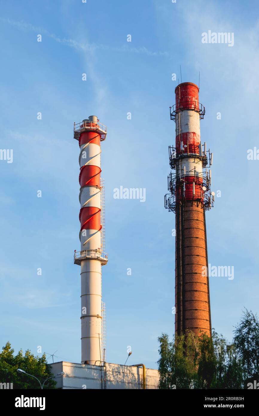 Boiler house chimney. Two towers against the clear blue sky. Industrial ...