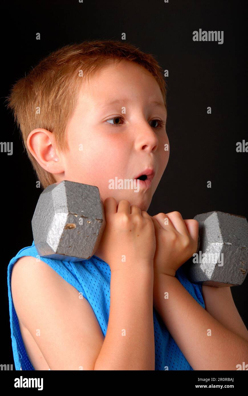 Young boy lifting weight that is too heavy Stock Photo - Alamy