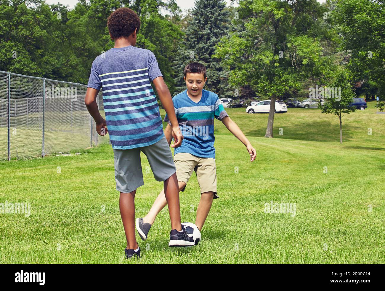 Havin a ball at the park. two young boys playing a game of soccer in ...
