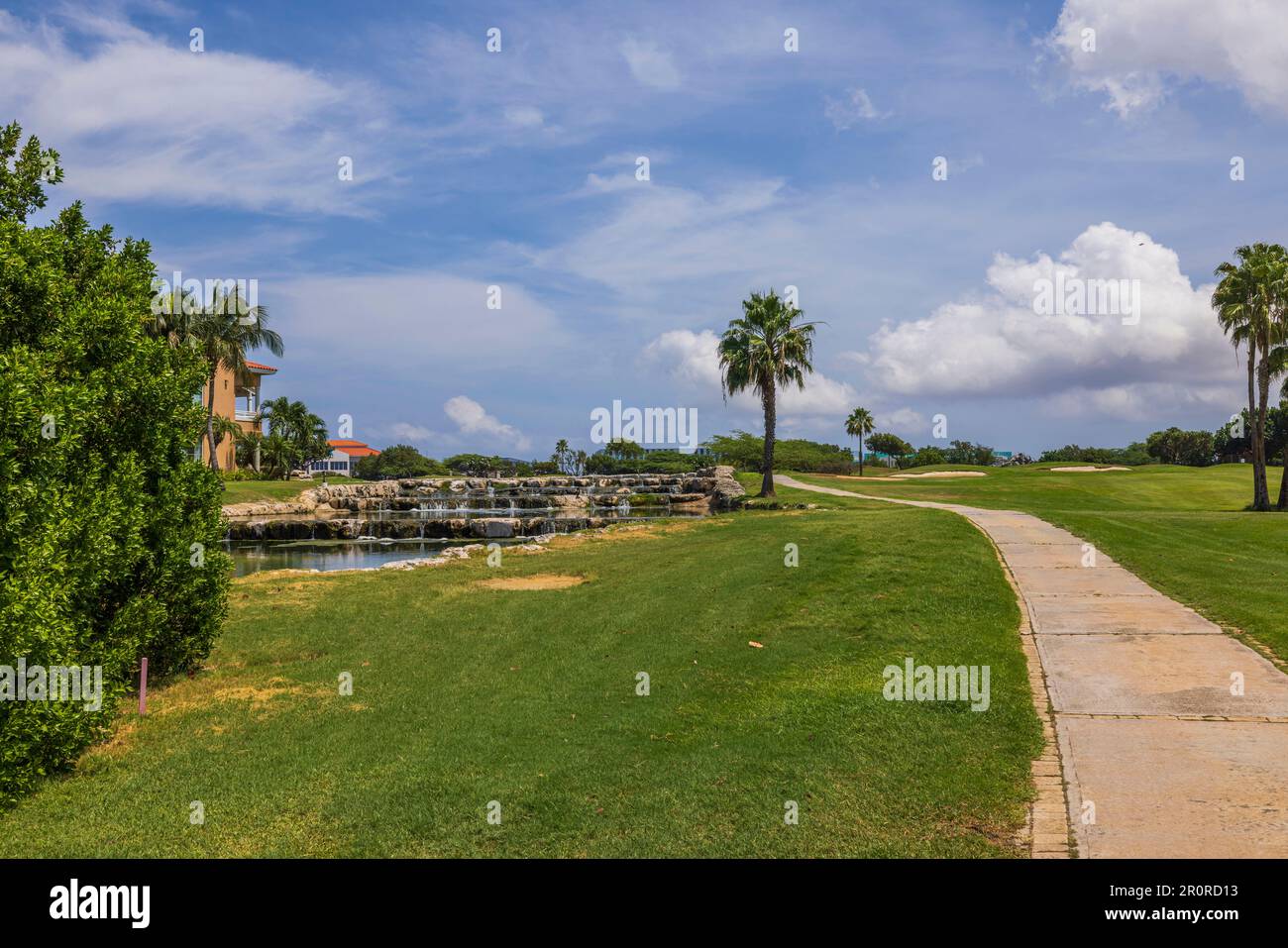 Beautiful tropical nature landscape. Stone path between pond and golf ...