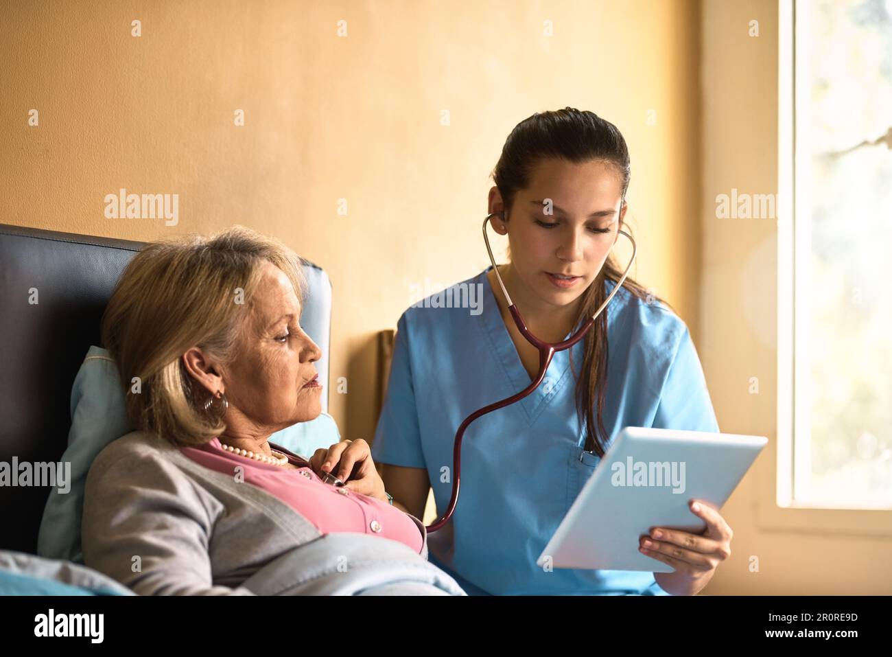 Lets put that on record. a nurse examining a senior patient with a ...