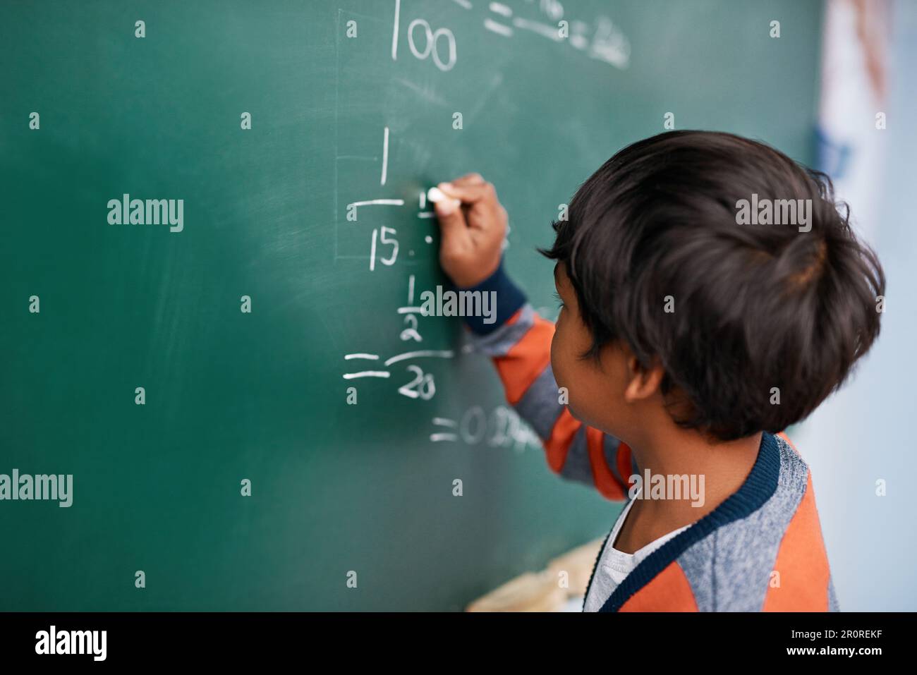 Easy as cake. a focussed young elementary school kid writing answers to ...