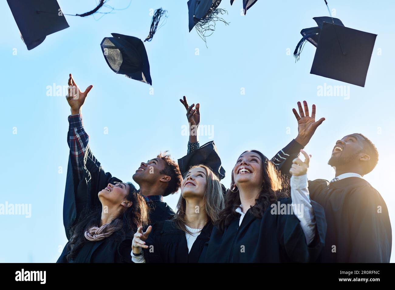 Its official. a group of students throwing their hats in the air on ...