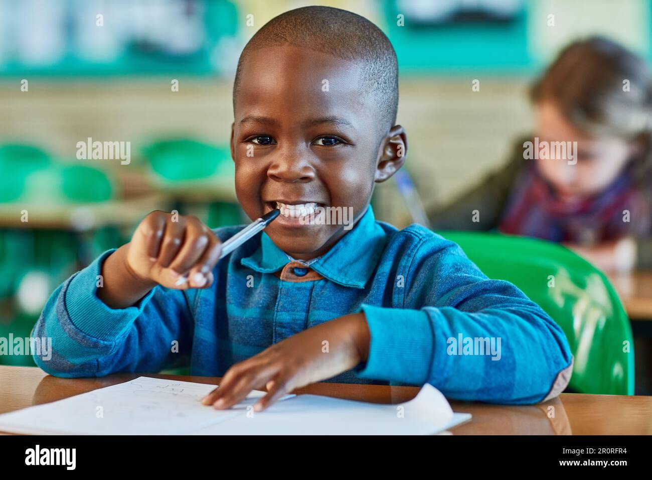 Hes all smiles when hes doing his work. an elementary school boy in the ...