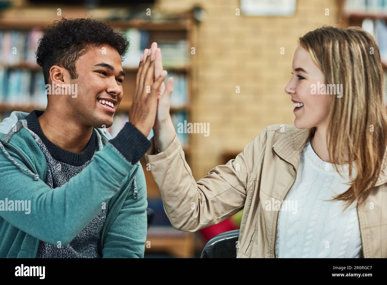 High five to a successful future. two university students high fiving ...