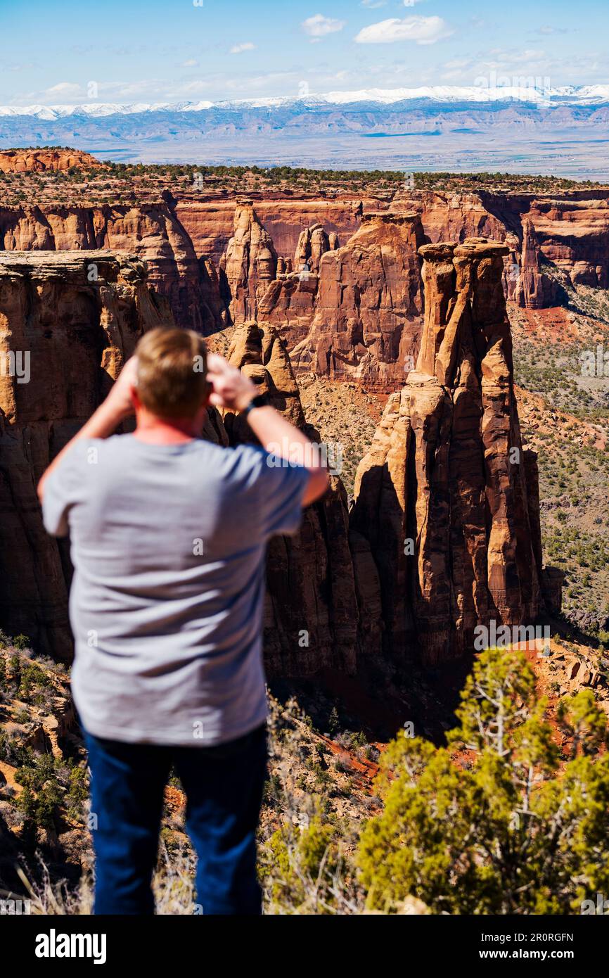 Male tourist photographing Kissing Couple sandstone formation; Monument ...