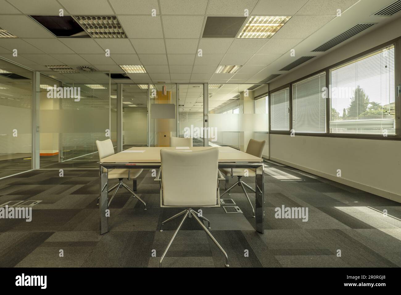 Empty offices with glass partitions, a lone desk in the center ...