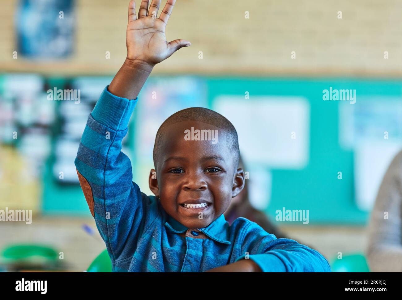 I know the answer teacher. an elementary school boy hand raised in the ...