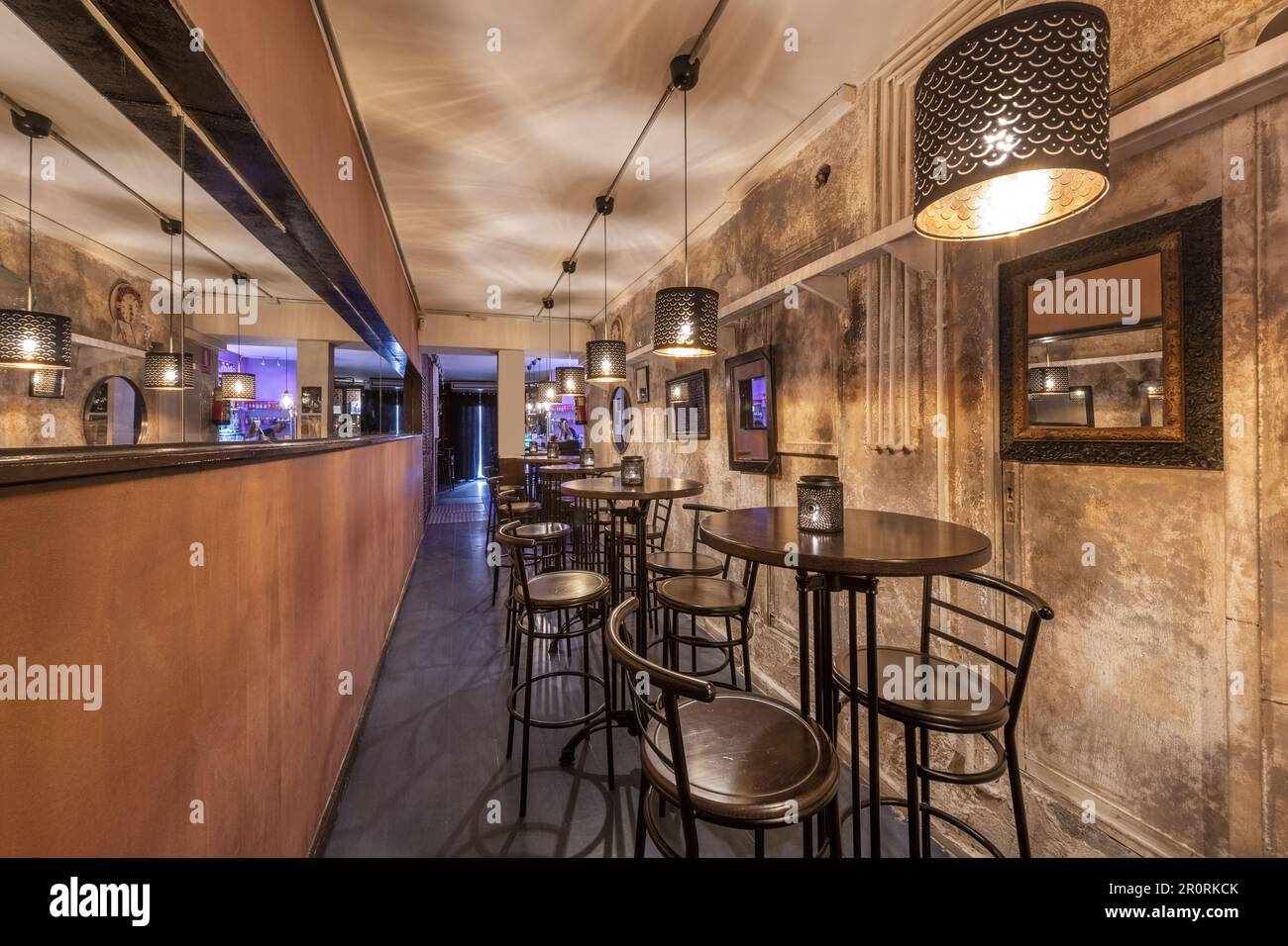 A late night cocktail bar with high tables with stools and a bar ...