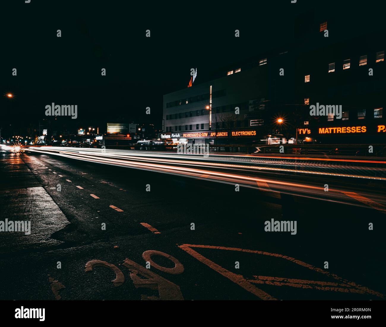 An urban street scene at night, with a variety of car lights traveling ...