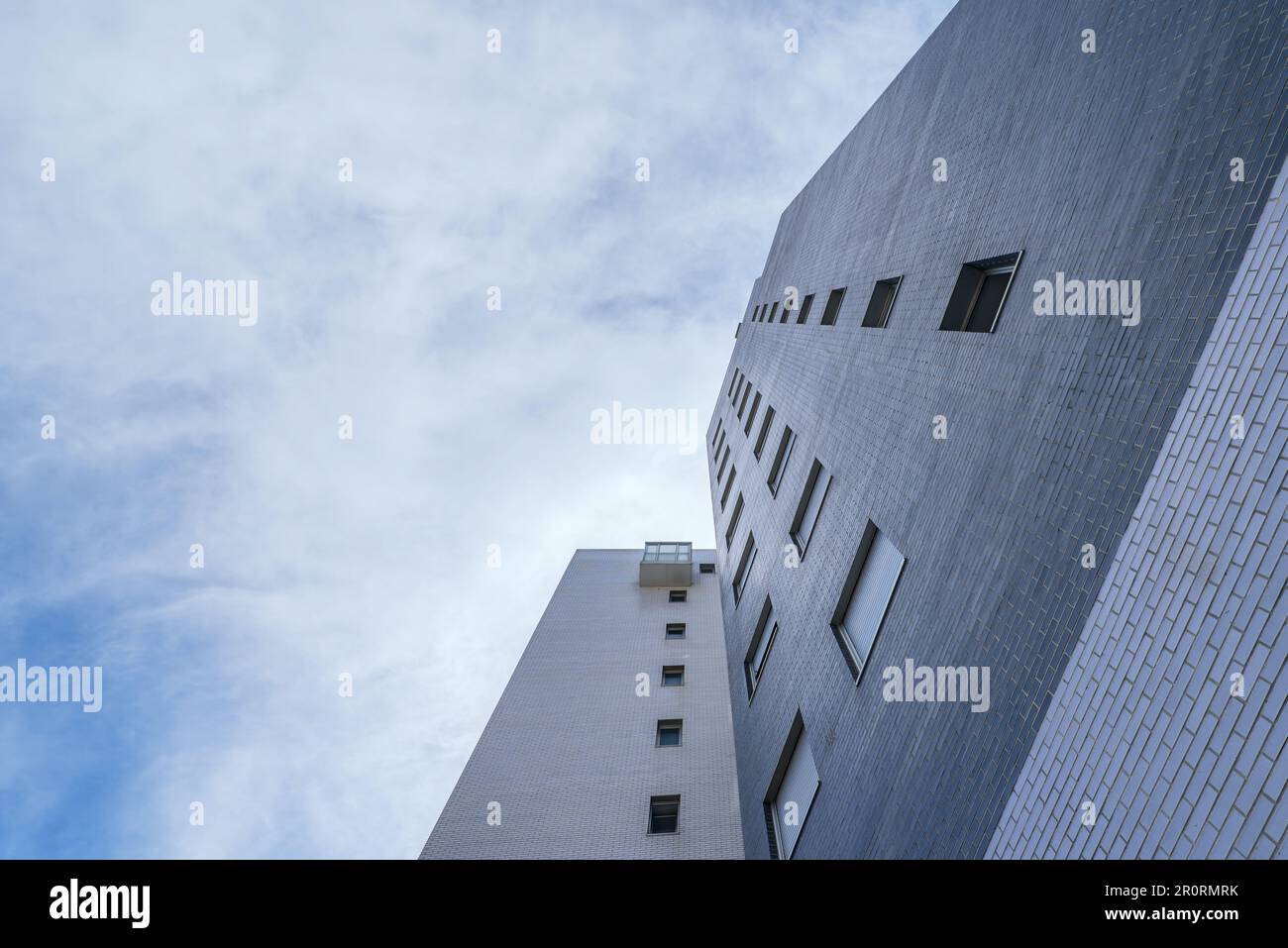 Facade of urban residential building of gray color at low angle with a ...