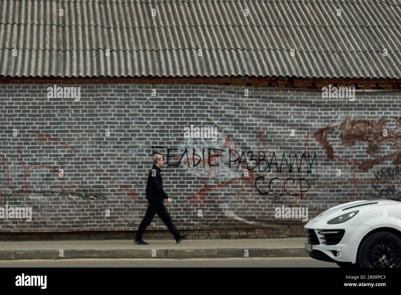 A man walks past the inscription on the repaired building that says ...