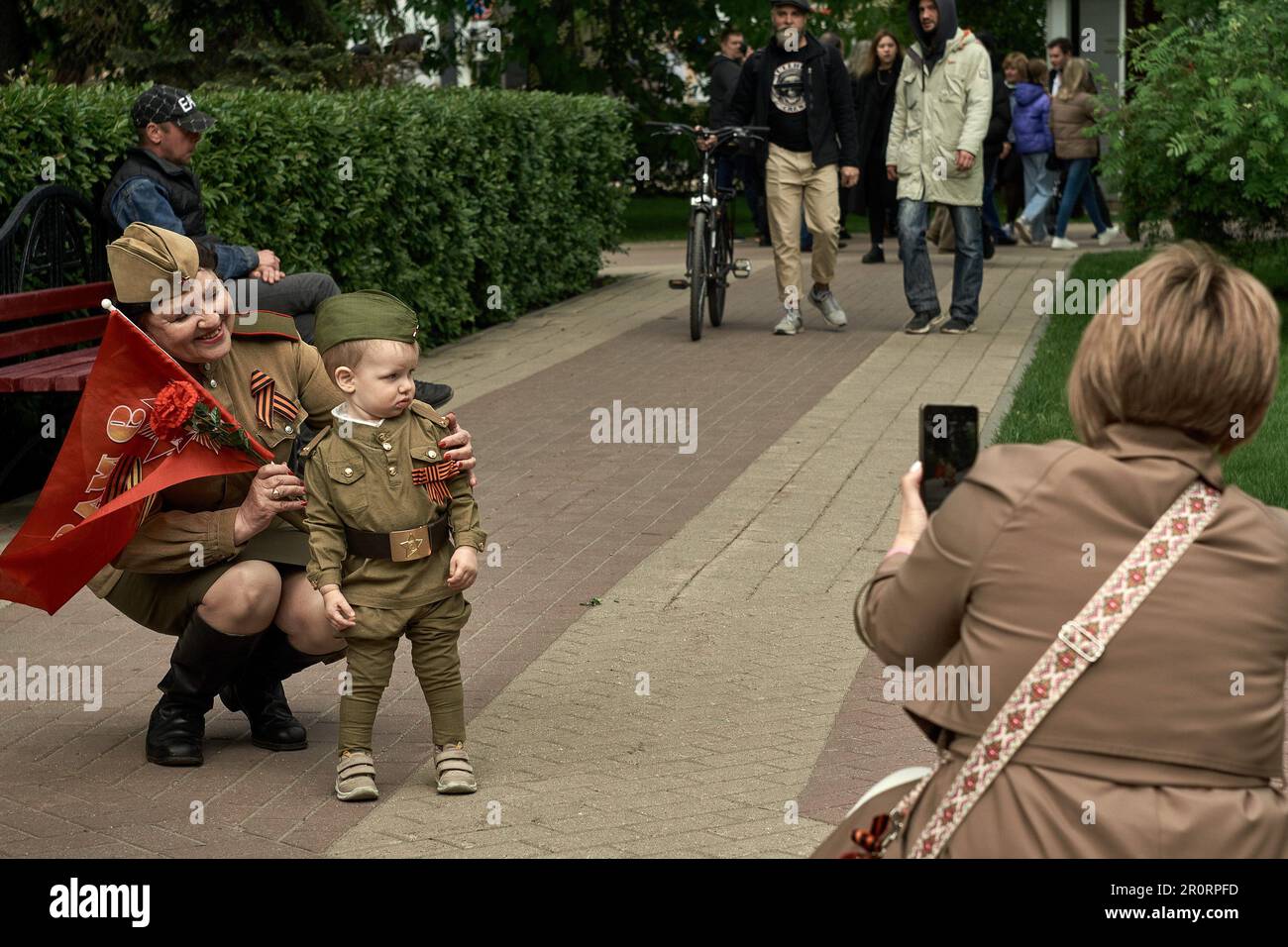 A woman and a kid take photos while wearing uniform of the Second World ...