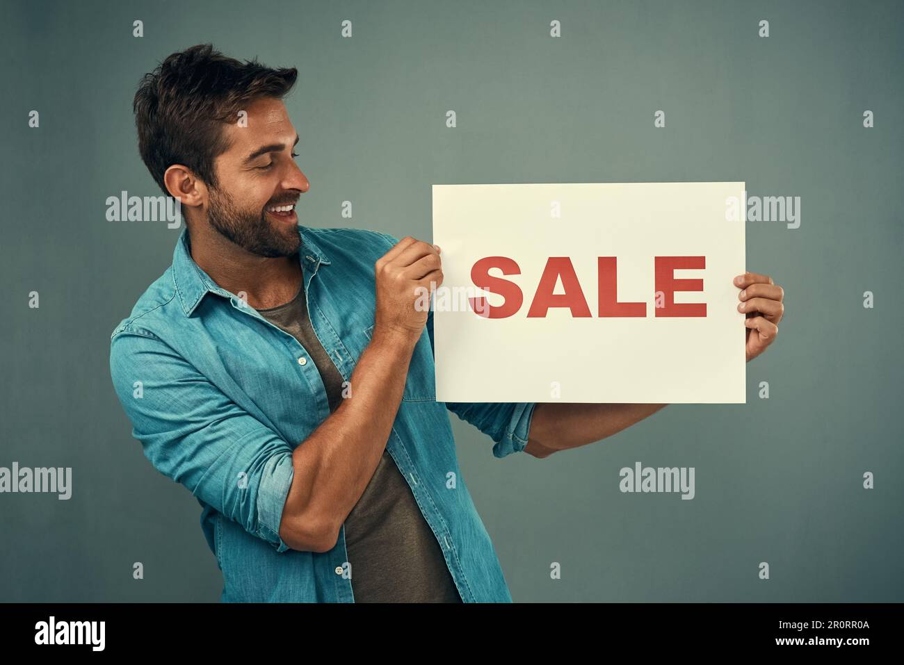 Its our biggest sale yet. Studio shot of a handsome young man holding a ...