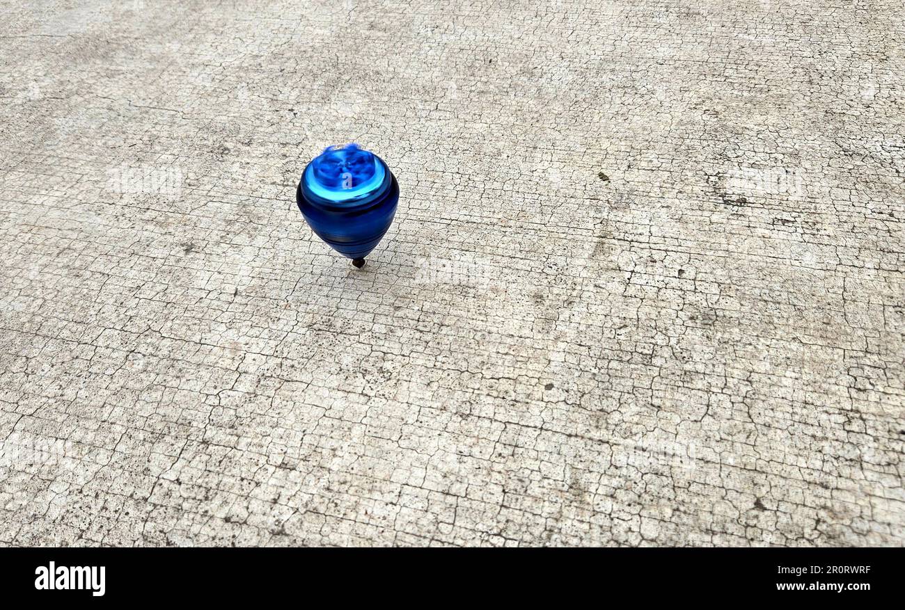 Blue spinning top, toy for children and adults, a type of spinning top ...