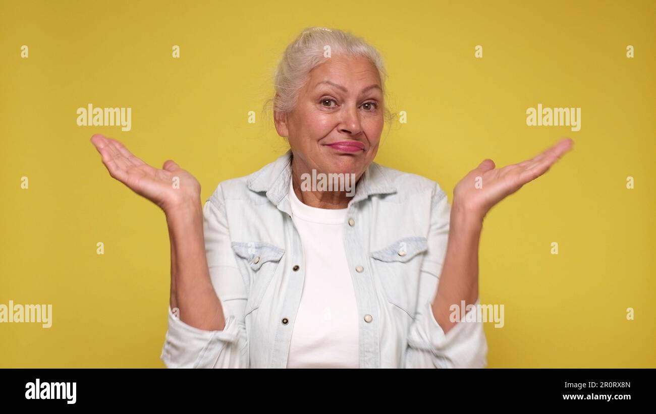 Senior European woman shrugs her shoulders in confusion Stock Photo - Alamy