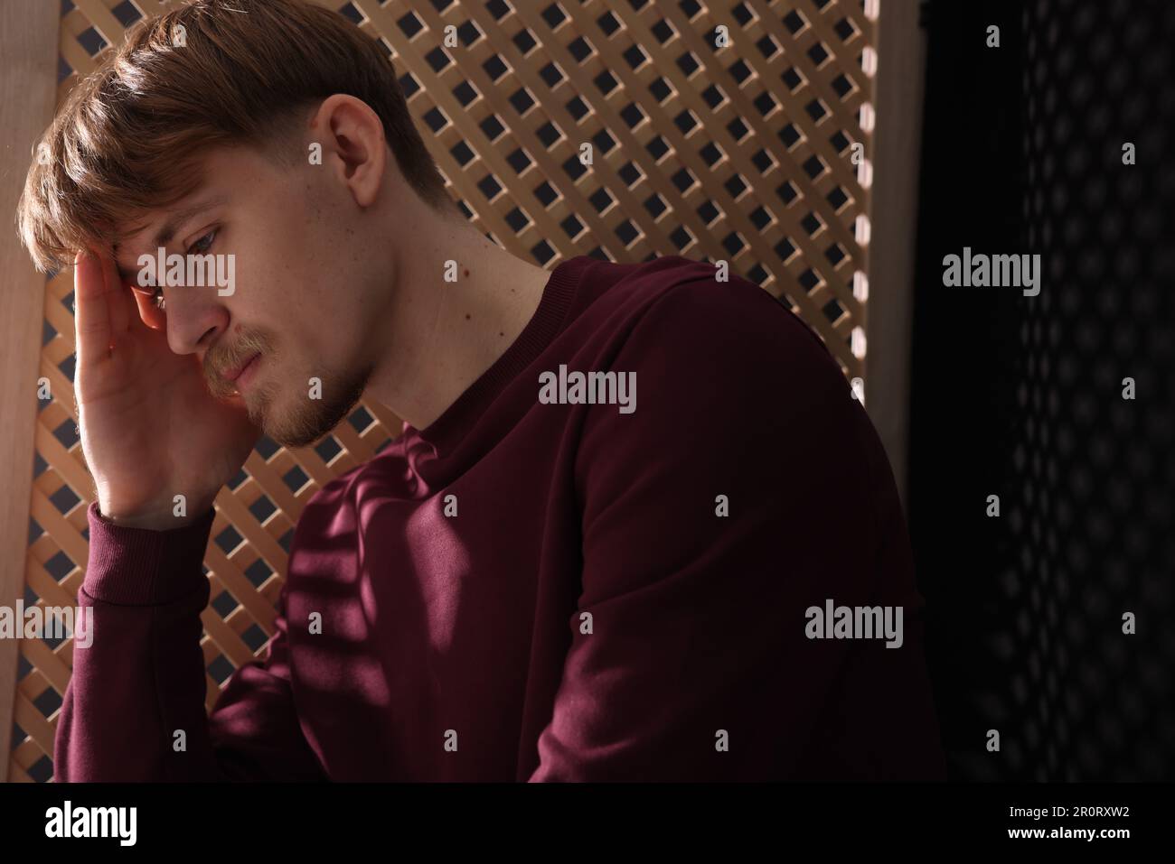 Upset young man during confession in booth Stock Photo - Alamy