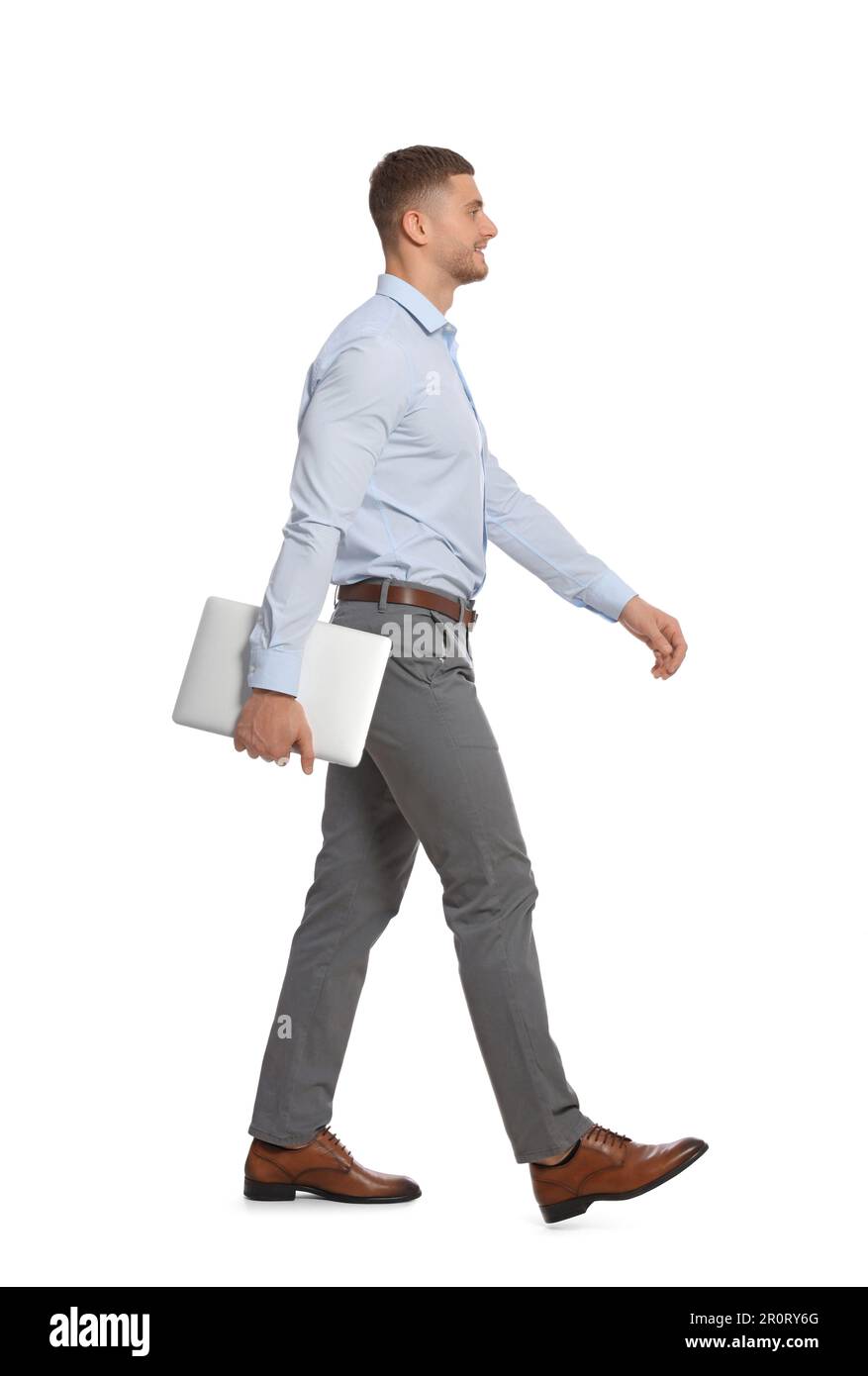 Man with laptop walking on white background Stock Photo - Alamy