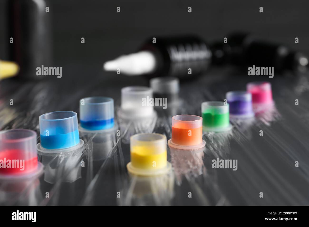 Many caps with colorful tattoo inks on table Stock Photo - Alamy