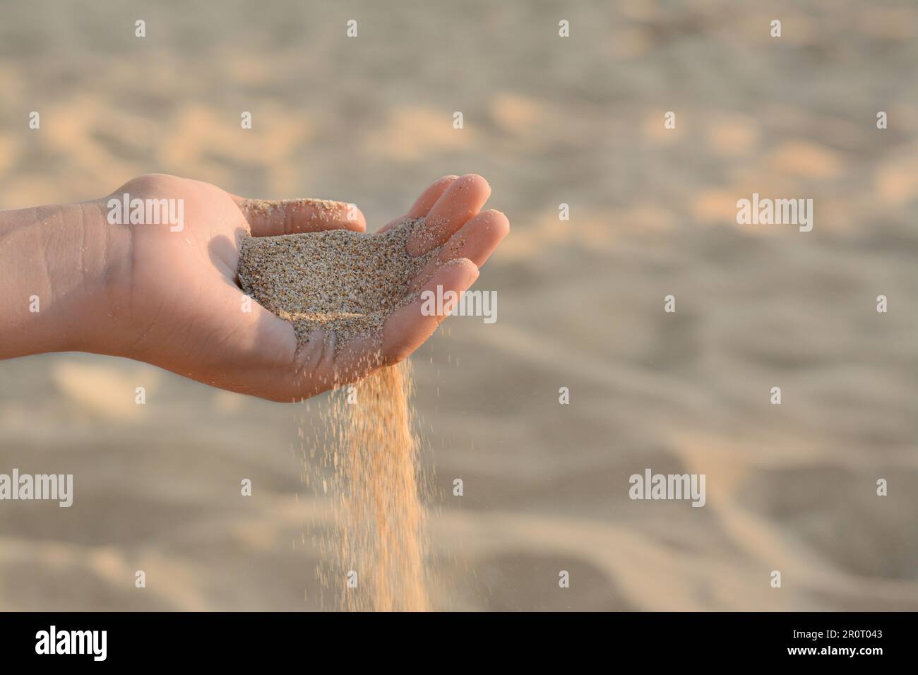 Girl pouring sand from hand outdoors, closeup. Fleeting time concept ...