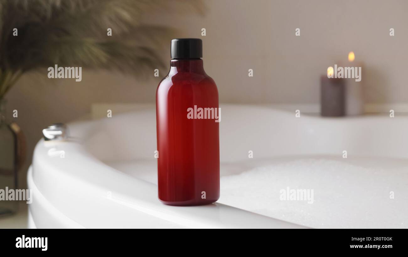 Red bottle of bubble bath on tub indoors, space for text Stock Photo ...