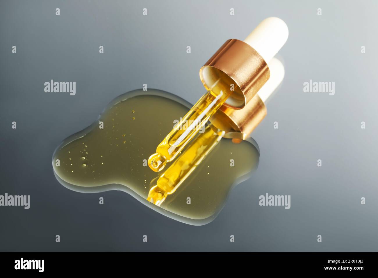 Yellow serum with pipette on mirror, closeup Stock Photo - Alamy