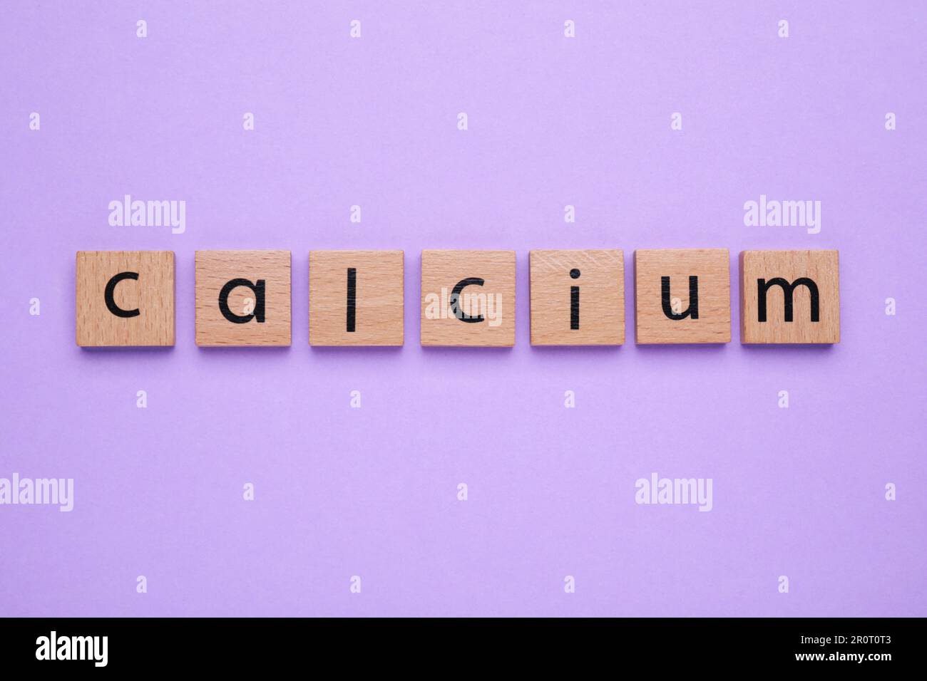 Word Calcium made of wooden cubes with letters on violet background ...