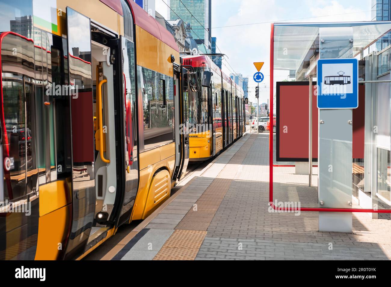 Modern streetcars near tram stop on sunny day. Public transport Stock ...