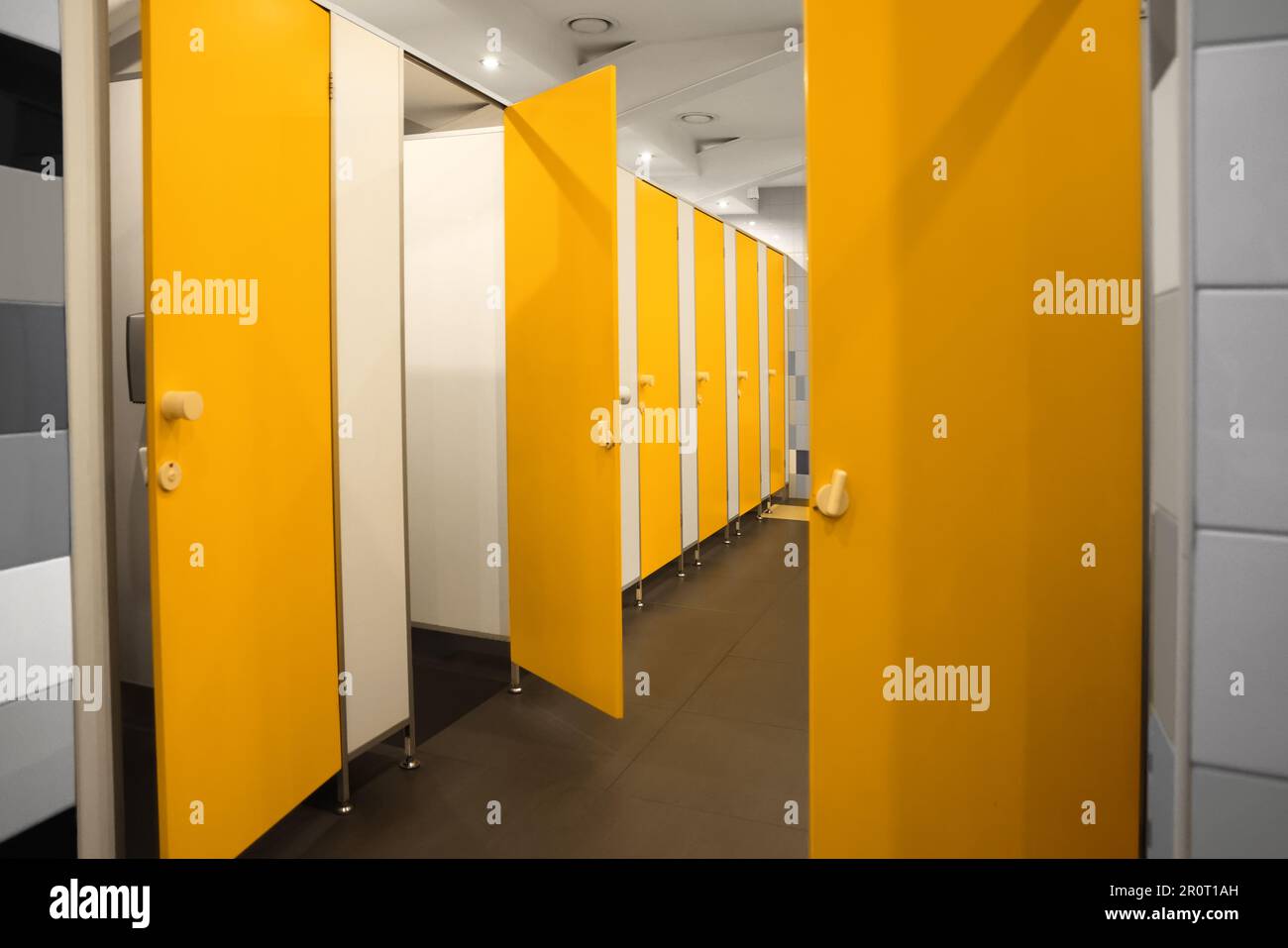 Public toilet interior with bright yellow stalls Stock Photo - Alamy
