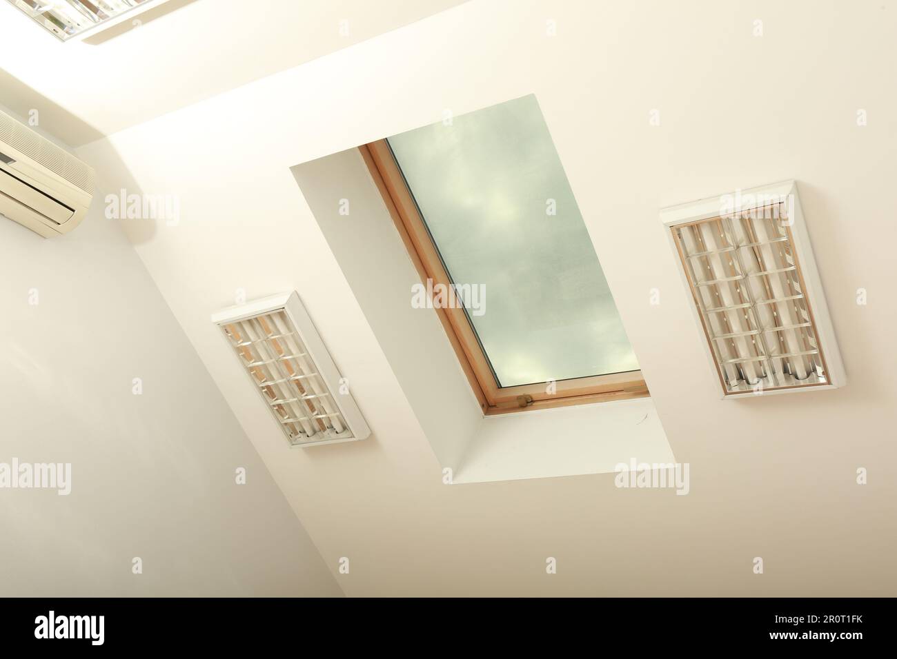Skylight roof window on slanted ceiling in attic room, low angle view ...
