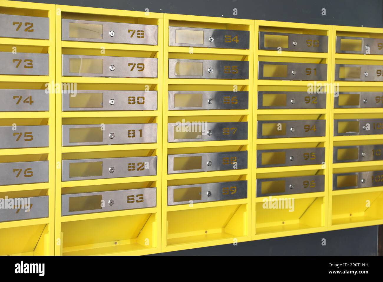 Many closed metal mailboxes with keyholes and numbers in post office ...