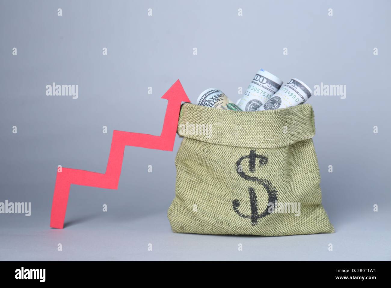 Economic profit. Money bag with banknotes and arrow on light grey ...