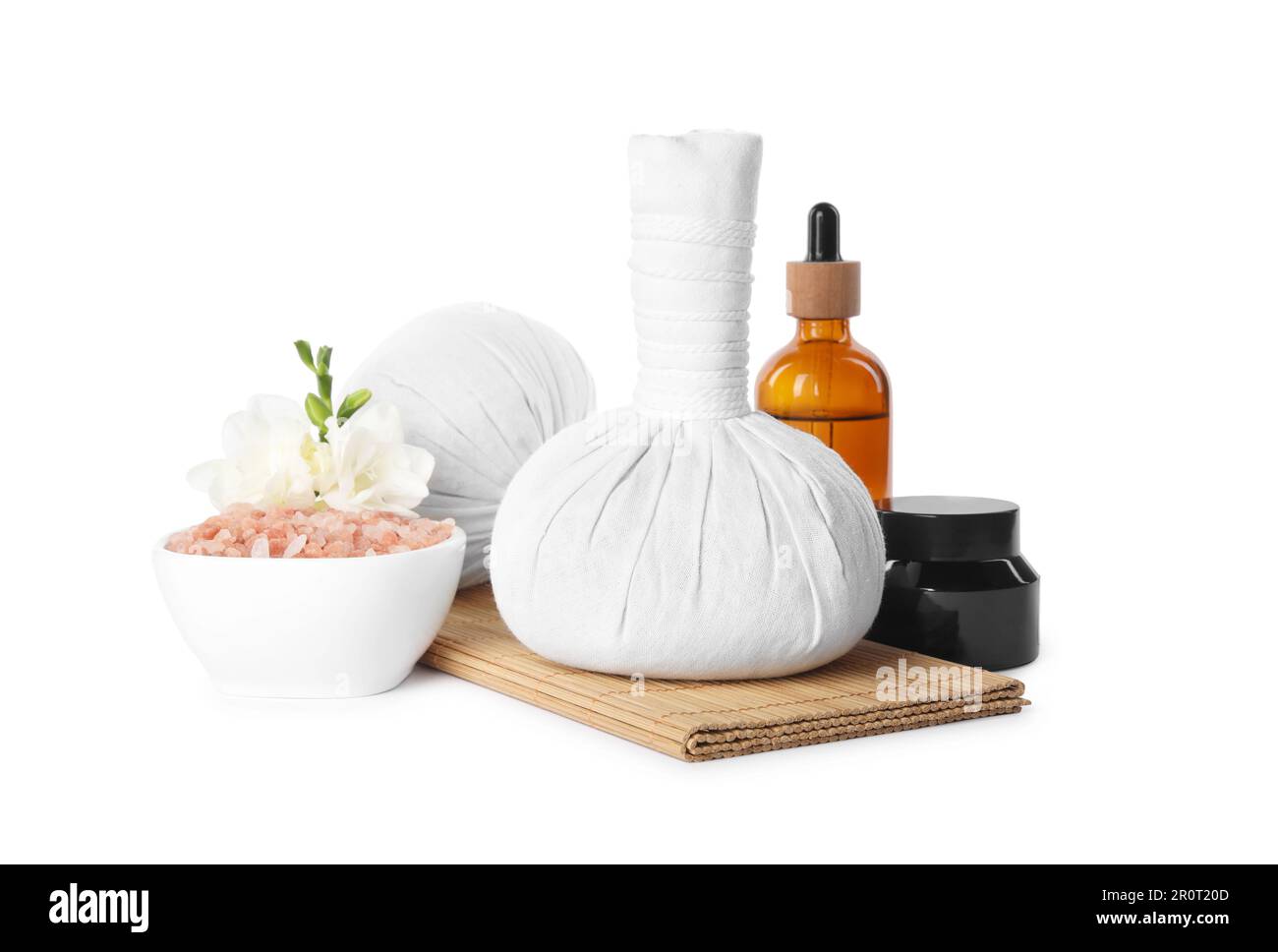 Herbal massage bags and different spa products on white background ...