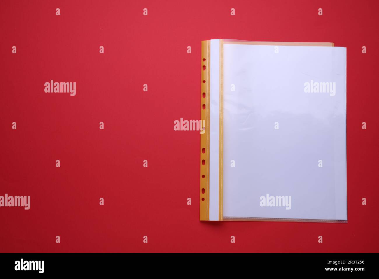 File folder with punched pockets and paper sheets on red background ...